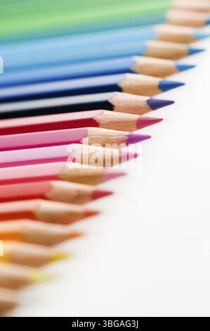Top view of the colorful crayons in the cup on the orange surface ...