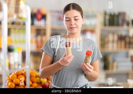 Young woman choosing seasoning herbs in grocery Stock Photo - Alamy