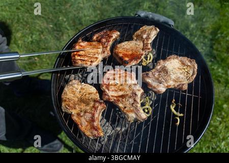 Juicy grilled pork steak seasoned with pepper on dark plate. Rustic ...
