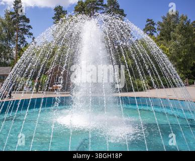 Round domed fountain, water splashes and jets on a sunny summer day ...