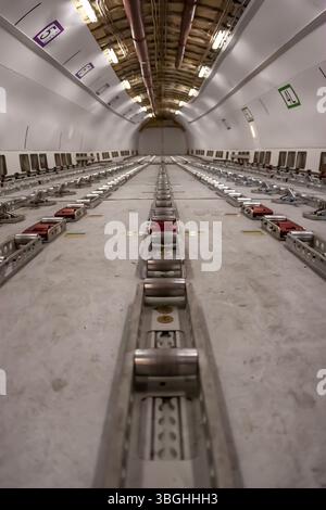 A commercial cargo aircraft rests on the tarmac of a bustling ...