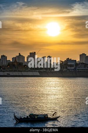 Serene golden hour sunset reflecting on tranquil water with silhouetted ...