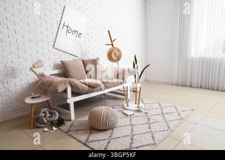Couch with tables and rack in messy living room Stock Photo - Alamy