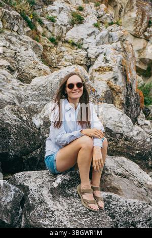 Young brunette in denim shirt caressing beautiful white horse in ...