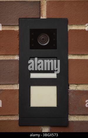 intercom panel with a video camera on the brick fence of private house ...