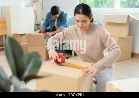 Moving house, relocation. Husband use tape pack box for movement ...