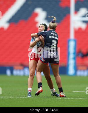 St Helens' Beri Salihi is tackled by Wigan Warriors' Isabel Rowe and ...