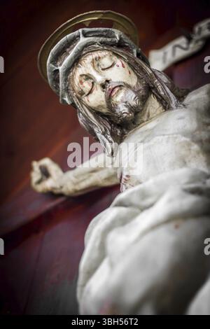 The bleeding body of Jesus Christ, crucified on a wooden cross. Shallow ...