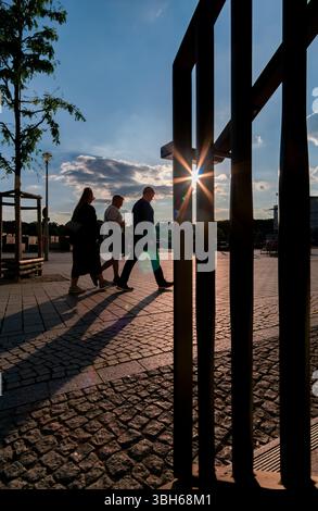 Pedestrians walking past with shadows and reflection , building on ...