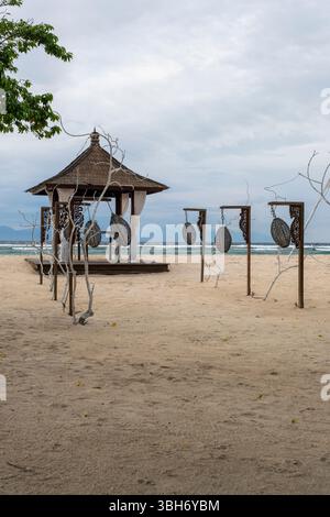 Beach scene with a pavilion and a few hanging lanterns. The pavilion is ...