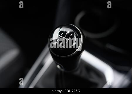 A gear shift with the numbers 1 through 6 on it. The shift is black and ...