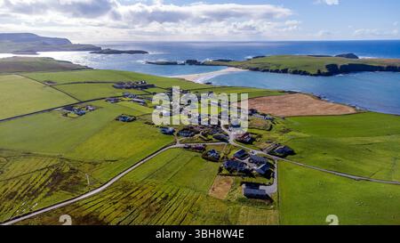 Sunny drone view of Bigton village with St Ninian’s Isle and tombolo in ...