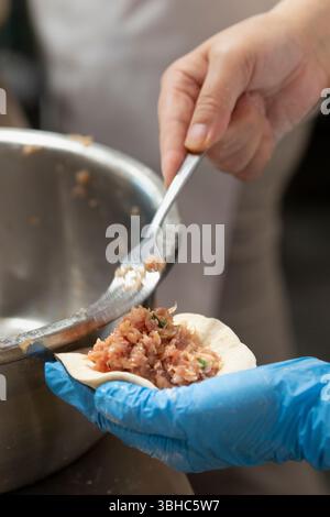 A woman makes bao in the kitchen. Bao, also known as baozi. It's a ...