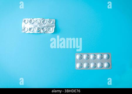 top view of used blister packs near round shape pills on crimson ...