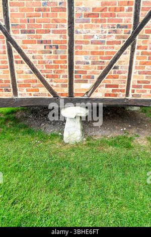 Staddle stone supporting a red brick and timber building Stock Photo ...