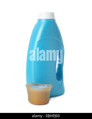 Bottle of fabric softener and cap on wooden table against white ...