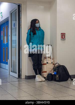 A woman wearing a face mask stands outside a shopping mall in Hong Kong ...