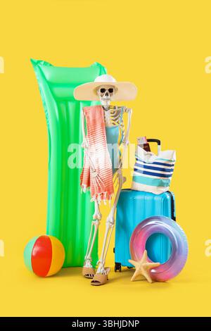 Human skeleton and beach accessories on orange background with space ...