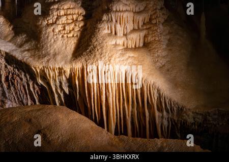 Spectacular golden stalactites and flowstone formations with blue ...