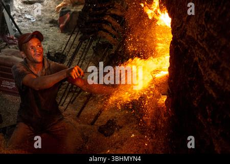 A worker throws sawdust onto the fire which heats a Hammam, bathhouse ...