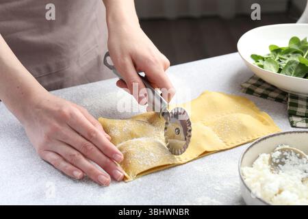 Woman cutting ravioli at light table, top view Stock Photo - Alamy
