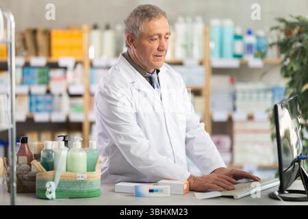 Pharmacist processing supply orders through pharmacy system Stock Photo ...