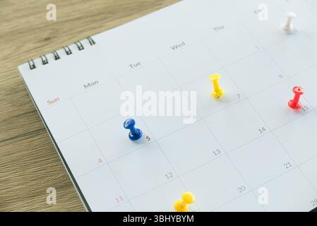 Colorful Push Pins on a Spiral-Bound Calendar Page for Planning and ...