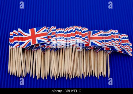 Small paper flags of United Kingdom on orange background, selective ...