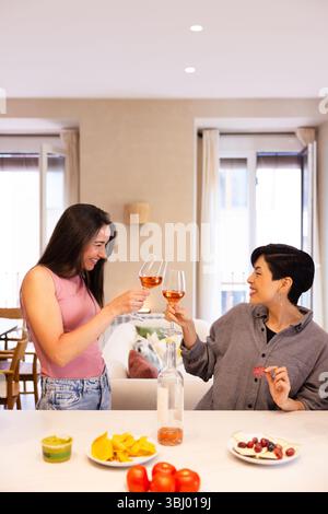 Two friends share a joyful moment while resting together in a sunny ...