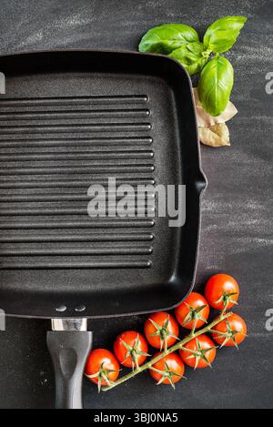 empty iron pan with fresh vegetables for cooking on dark table Stock ...