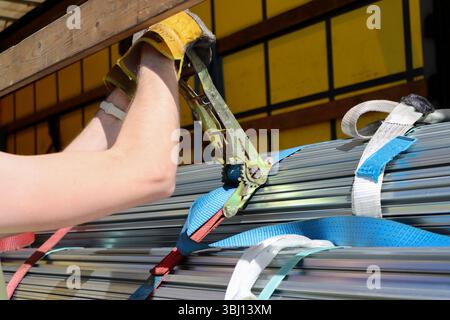 a man secures a load with a lashing strap Stock Photo - Alamy