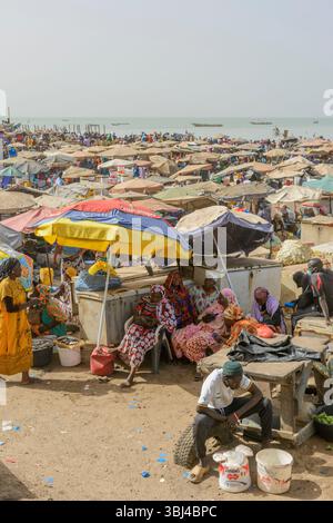 Umbrellas shade food stalls from the sun at the busy daily fish market ...