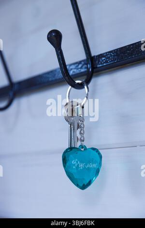 Holder with key hanging on color wall Stock Photo - Alamy