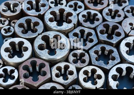 Bolt threading dies. Many dies of different sizes, top view. Hand tool ...