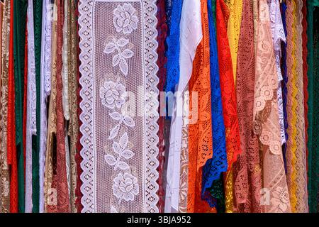 Colorful traditional lace fabrics hanging in a street market in Brazil ...