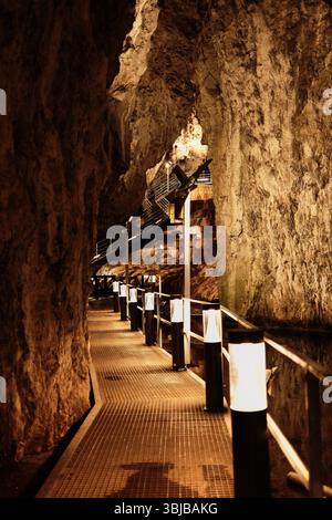 Well-lit path through Stopica Cave with modern lights and rocky ...
