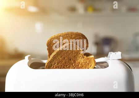 Two roasted toast bread popping up of toaster Stock Photo - Alamy