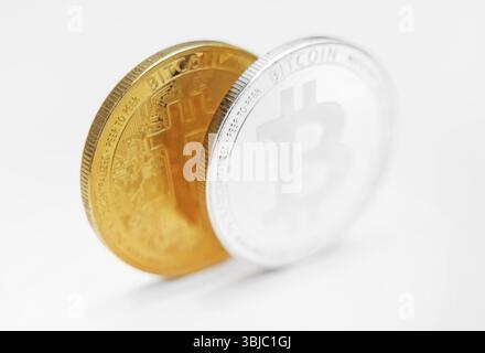 Physical version of silver and golden bitcoins on white background ...
