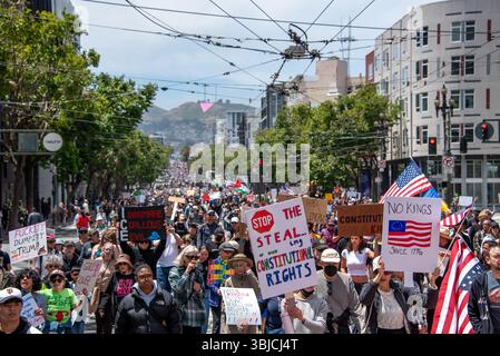 Protesters carry signs and march in front of a townhouse owned by ...