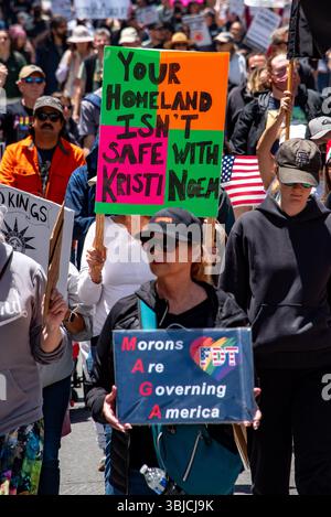 Protesters hold “No Kings” signs during a political demonstration in ...