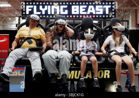 Bucharest, Romania. 14th June, 2025. A man arranges VR goggles for his child during the opening ...