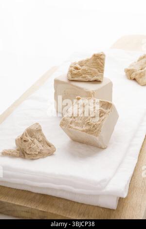 Fresh yeast blocks on wooden board isolated on white background ...
