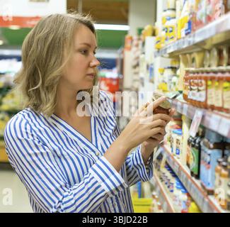 Woman choosing sauce in the store Stock Photo - Alamy