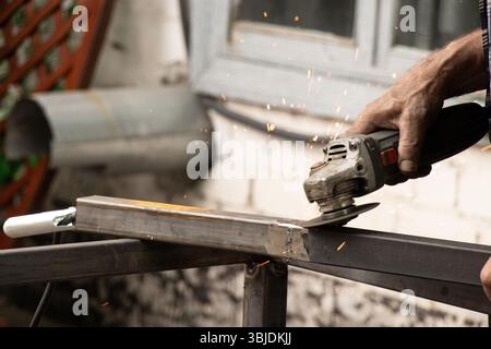 Grinding a weld on metal structures with a grinder, a master working on ...