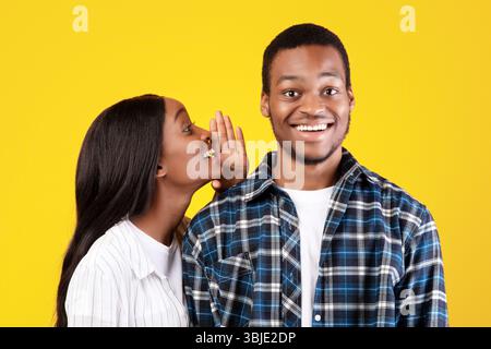A young guy whispers in the ear of a girl on a green lawn Stock Photo ...