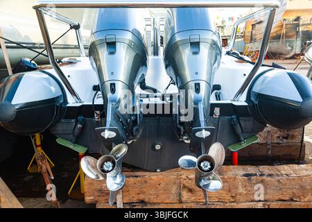 The back of a motor yacht dry docked on wooden blocks and supported by ...