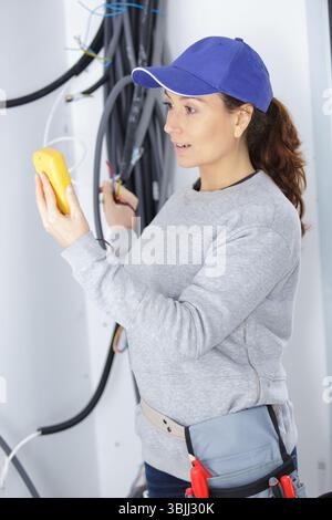 a happy female electrician using multimeter Stock Photo - Alamy