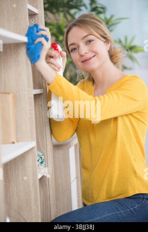 beautiful woman dusting shelves at home Stock Photo - Alamy