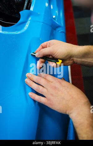 Cutting blue PPF with blade. Cutting blue paint protection film with ...