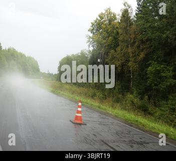 Road-building. Fresh laid asphalt watered, water evaporation over new ...